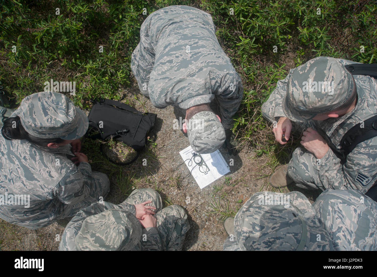 U.S. Air Force Airmen assigned to the 18th Medical Group examine a map ...