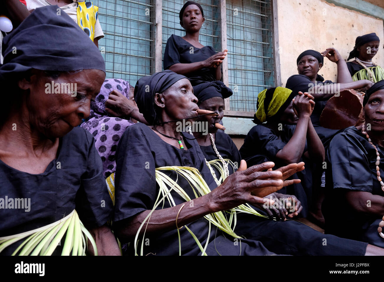 Woman in black traditional costume blowing wooden whistle during a ...