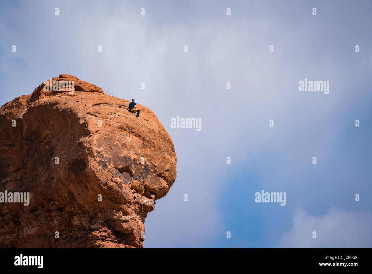 Rock climber on top of ascent in Arches national Park, Utah Stock Photo ...