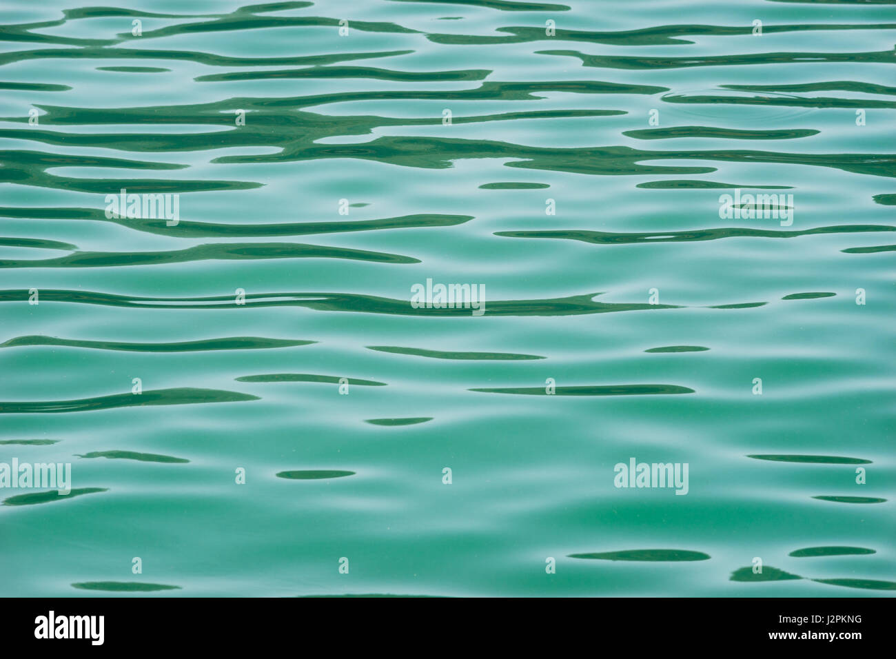 Ripple on green color lake water, natural background Stock Photo - Alamy