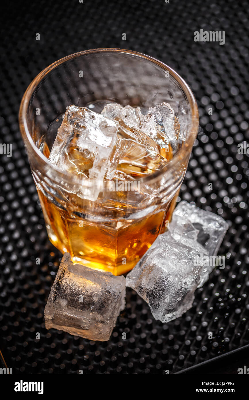 Glass of scotch whiskey with ice cubes Stock Photo - Alamy
