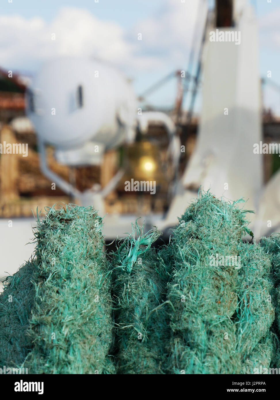 closeup thick green rope worn on the ship at Sunny summer day, vertical ...