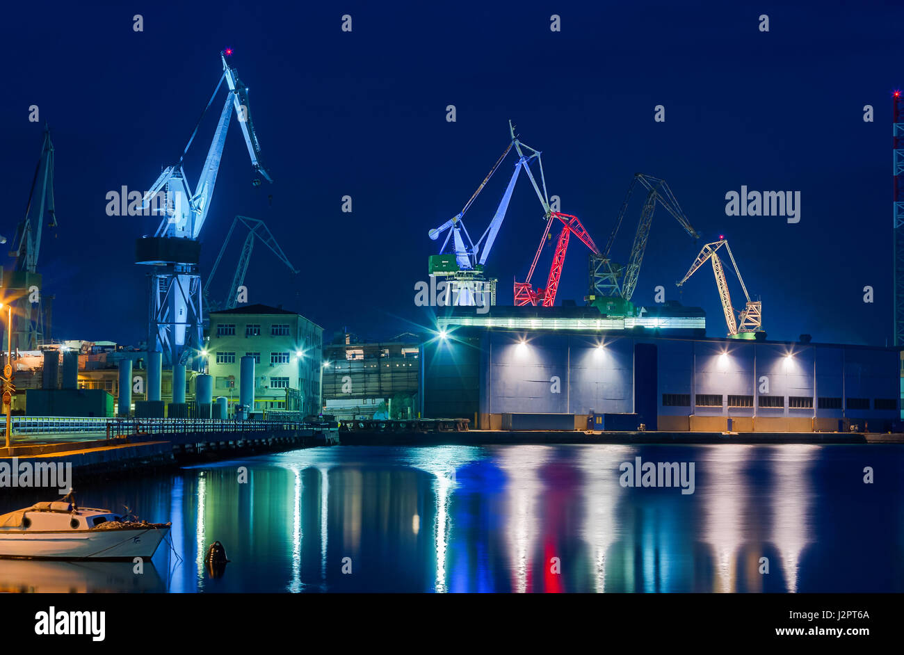 Giant cranes at shipyard at night covered in light Stock Photo - Alamy