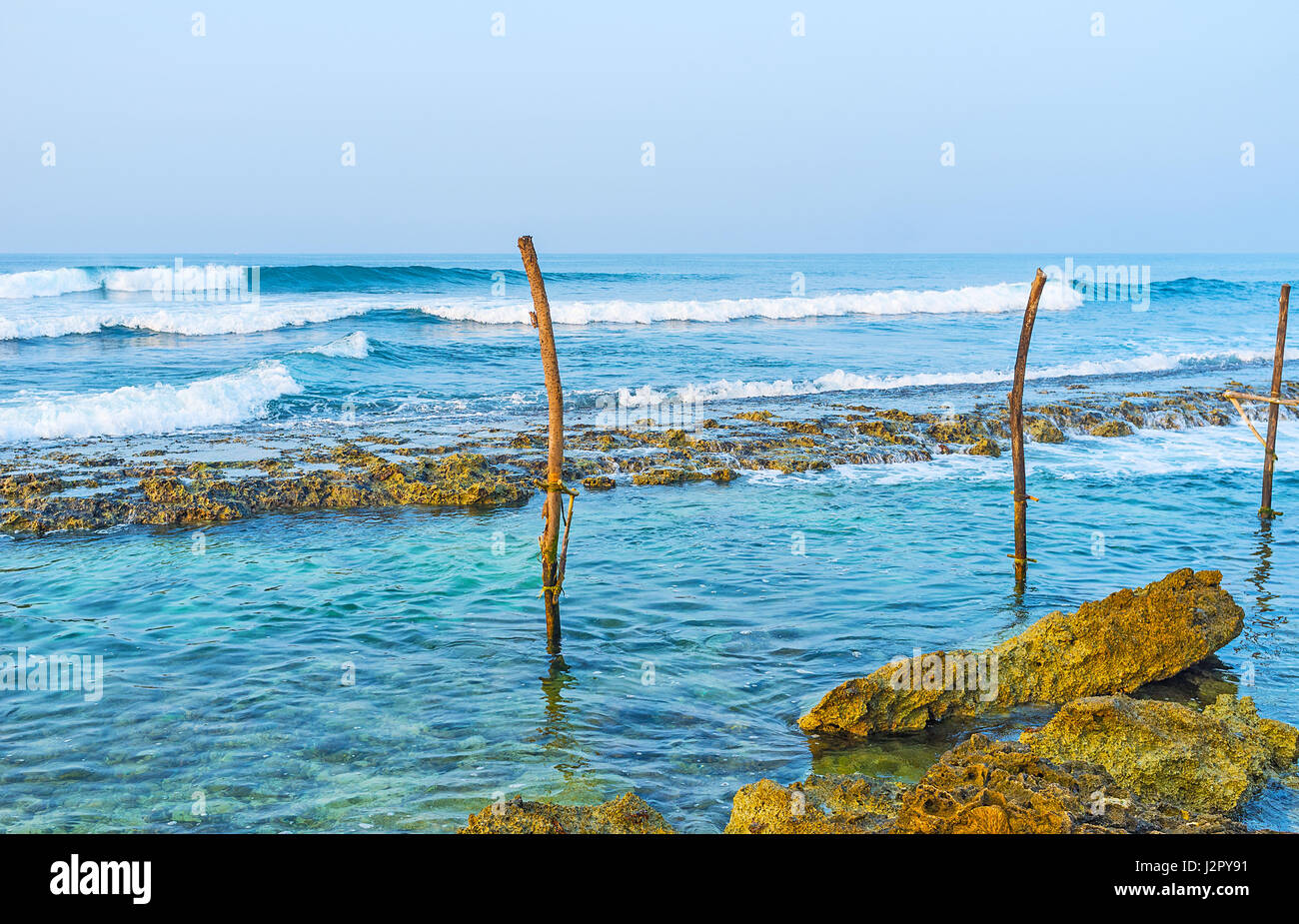The morning waves at the Ahangama beach with the old fishing sticks on ...