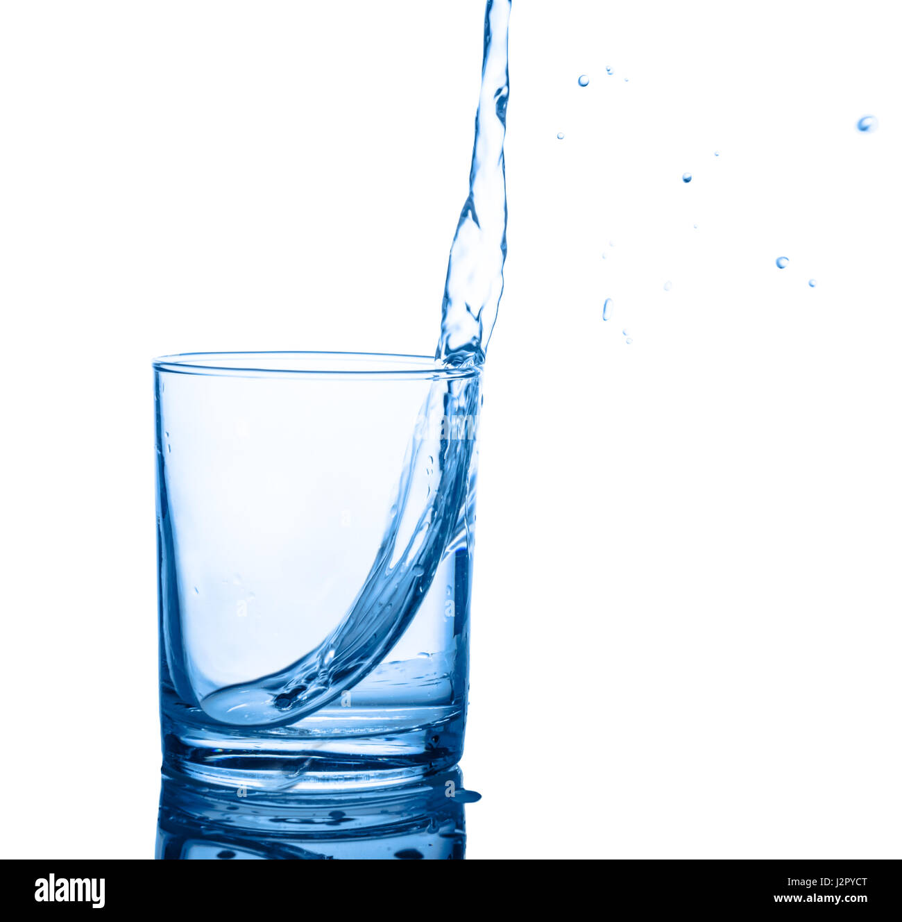 pouring blue water in transparent glass with drops isolated on white ...