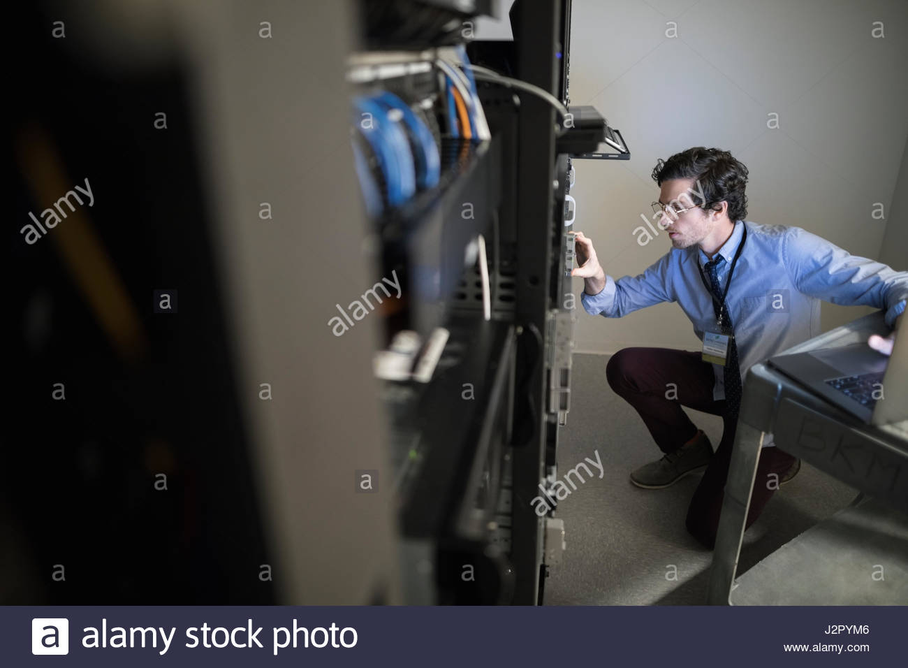 Technician with laptop working at server panel in server room Stock ...