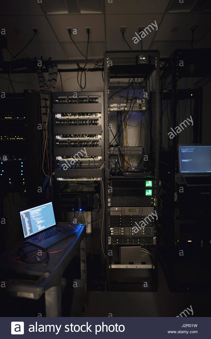 Laptop and server panels in dark server room Stock Photo - Alamy