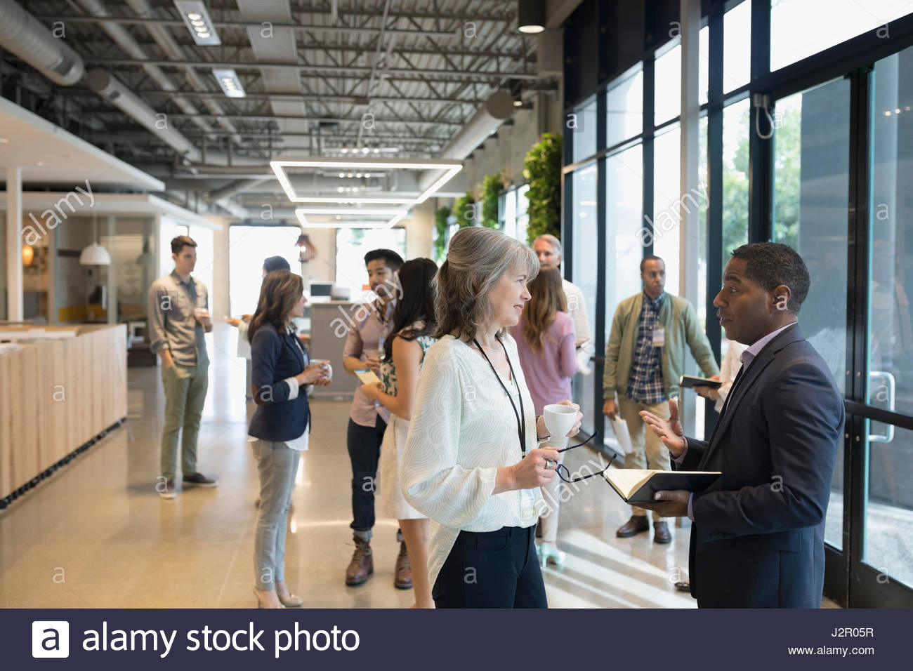 Business people networking in office lobby Stock Photo - Alamy