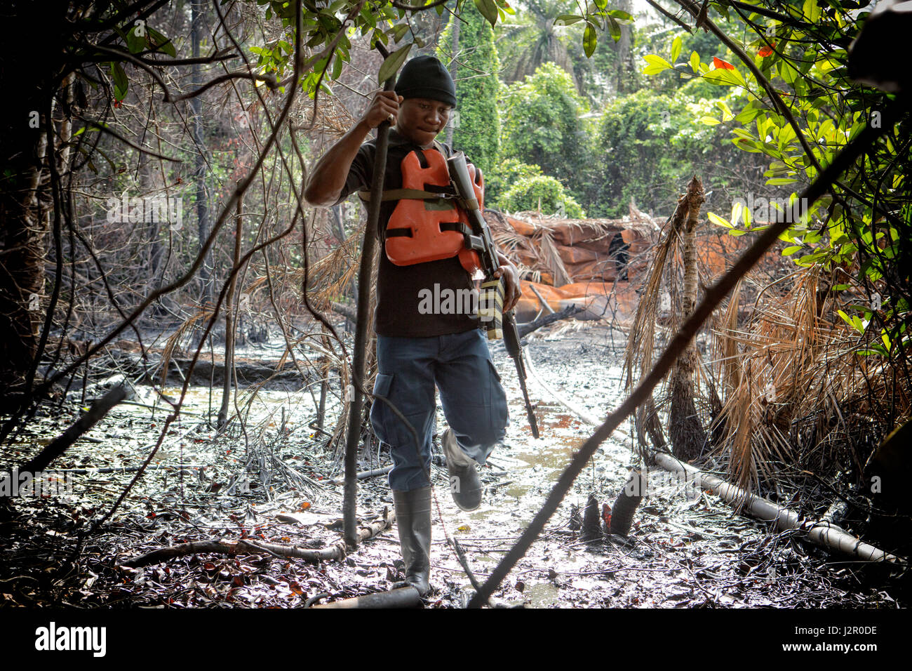 A sailor makes his way through swamp like terrain caused by oil spill ...