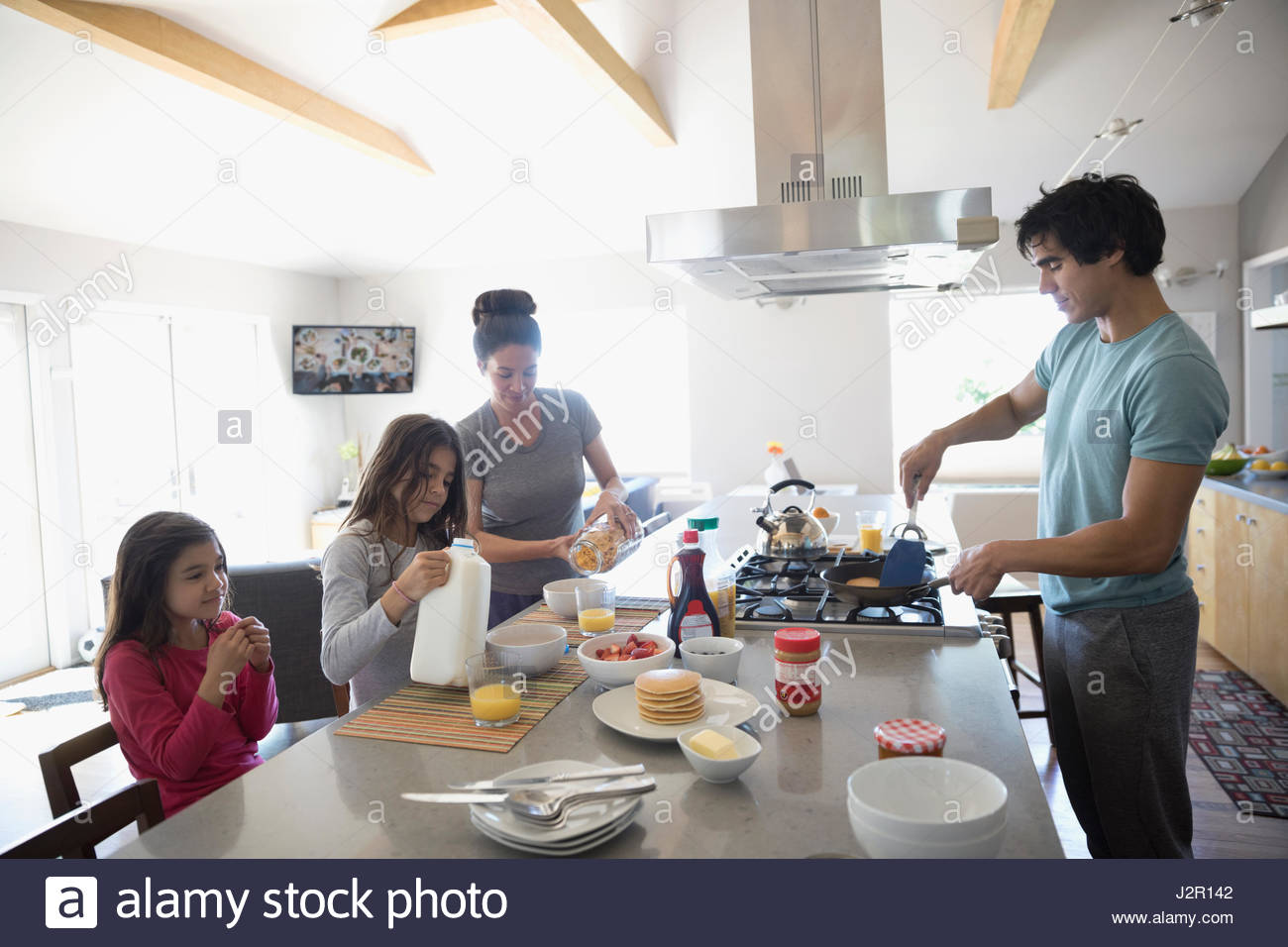 Family cooking and eating breakfast in kitchen Stock Photo - Alamy