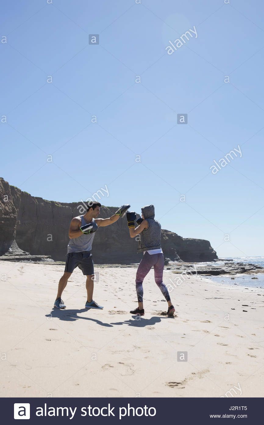 Man and woman boxing on sunny beach Stock Photo - Alamy