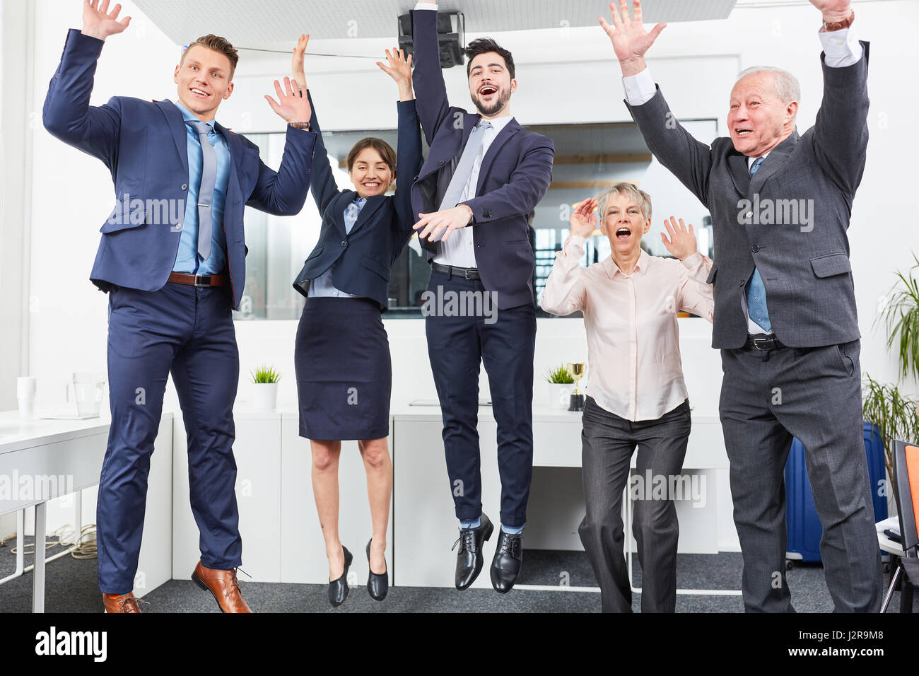 Business team jumping in celebration with enthusiasm for recent success ...