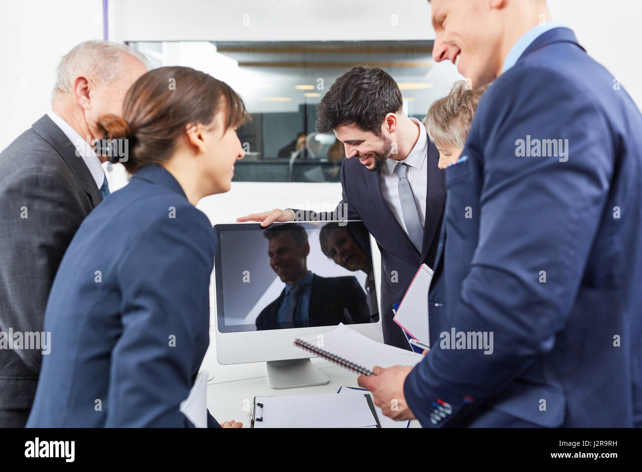 Business people with computer monitor smiling as a group Stock Photo ...