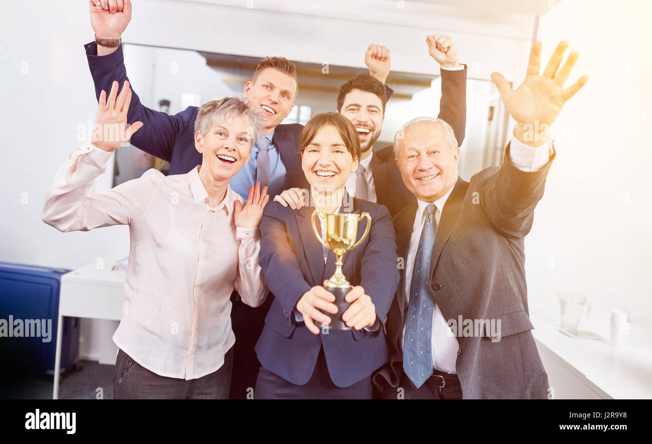 Start-up team with winner trophy in success celebration Stock Photo - Alamy