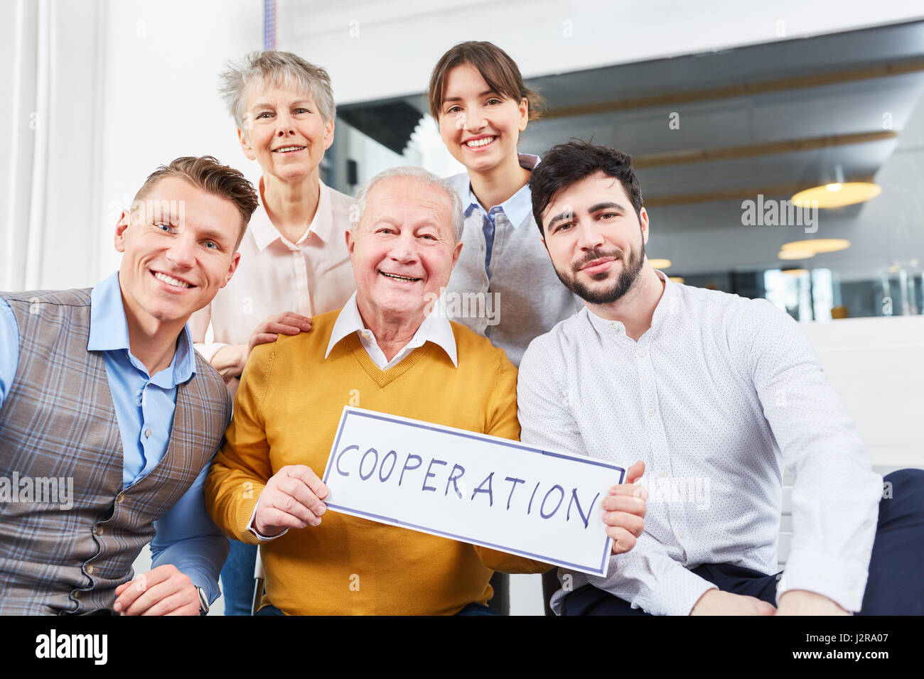 Business team in workshop for cooperation and team building hold sign ...