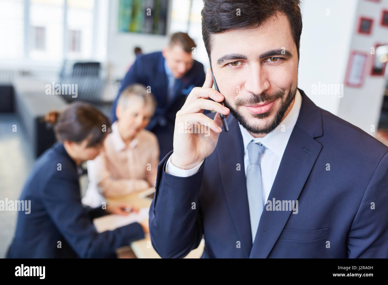 Manager calling with smartphone in business meeting at office Stock ...