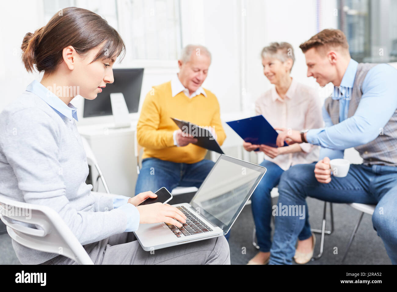 Woman researching in the internet with laptop at business meeting Stock ...