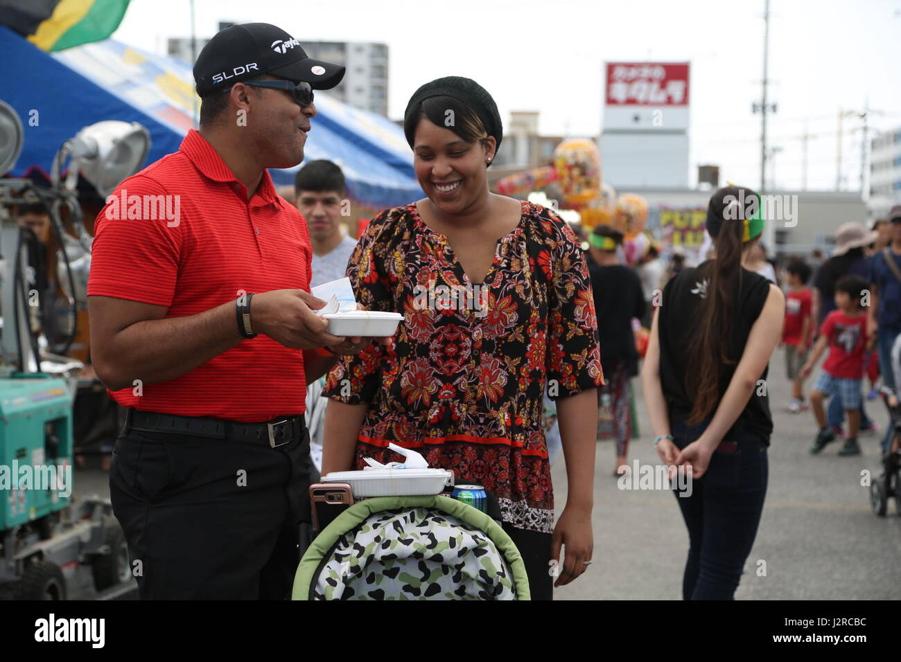 A couple enjoys Jamaican jerk food April 23 at the Camp Foster Festival ...