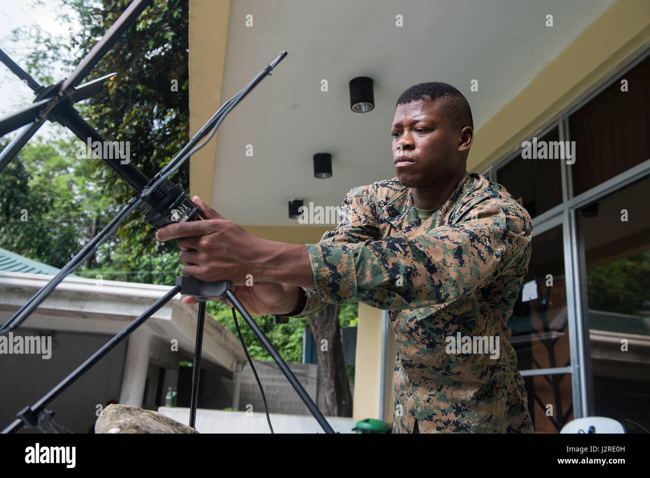 U.S. Marine Staff Sgt. Alexander Davis adjusts a satellite ...
