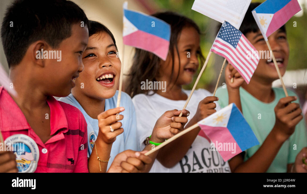 Filipino children wave U.S. and Philippine flags during a ...