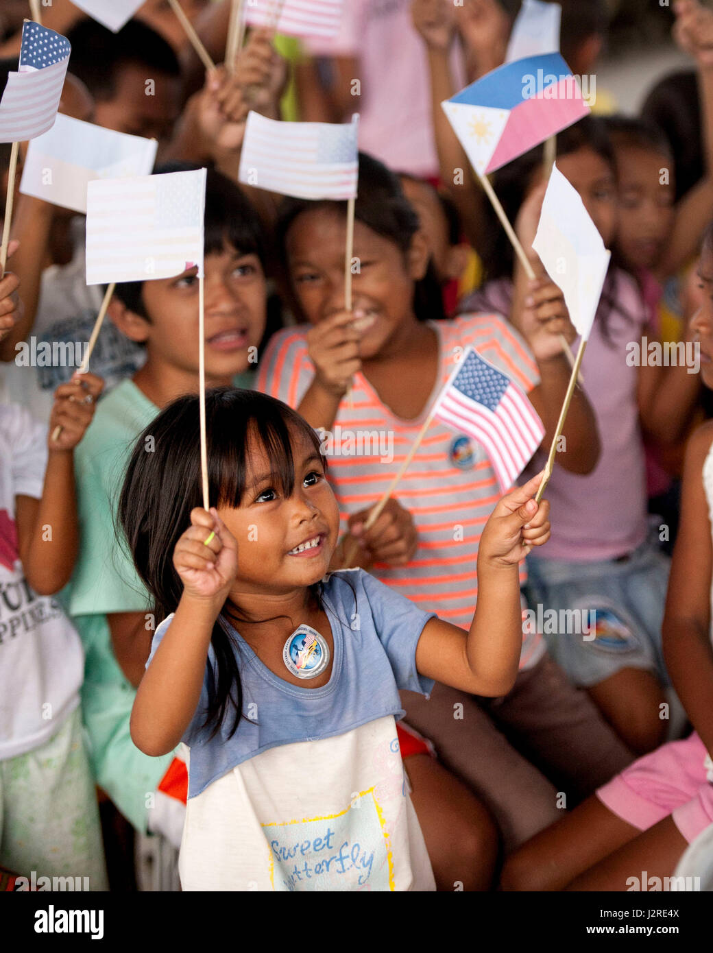Filipino children wave U.S. and Philippine flags during a ...