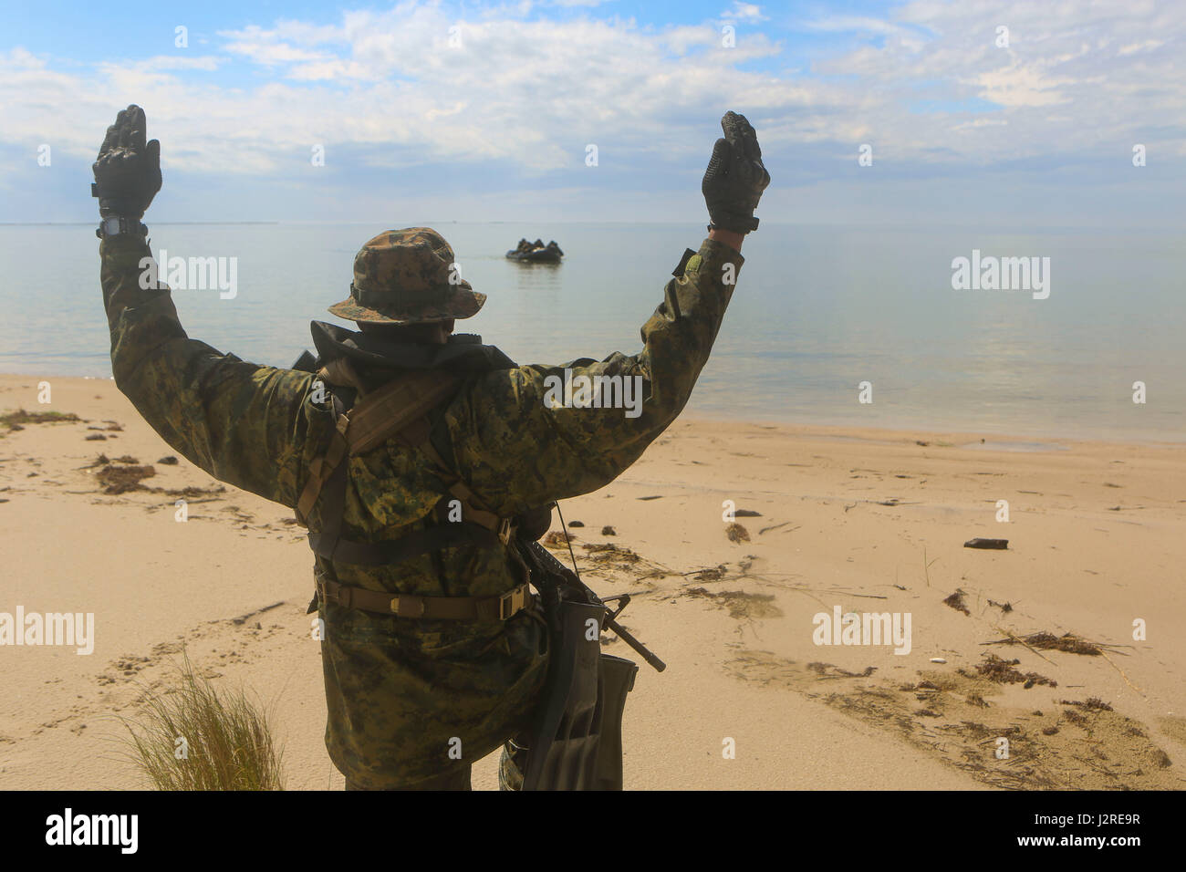 A Marine signals to his boat team during a weeklong training exercise ...