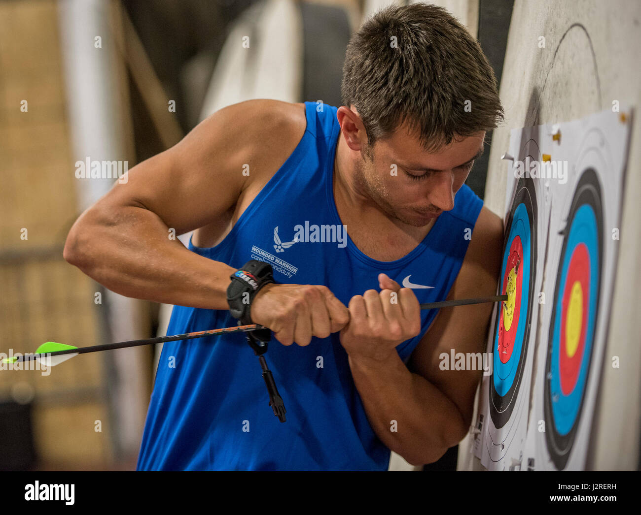 A Warrior CARE athlete, Kenneth Guinn pulls his arrows from the target ...