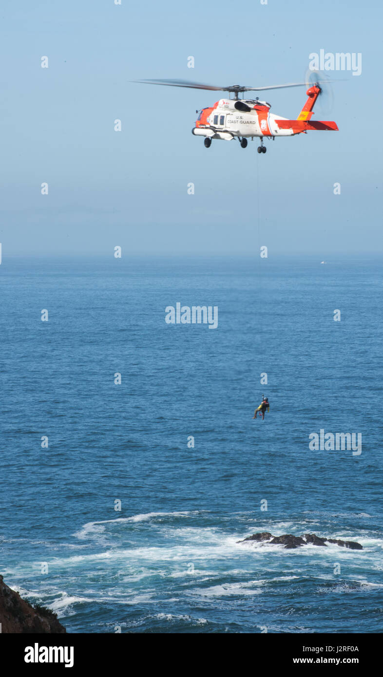An aircrew from Air Station San Diego is hoisting up a member up to a ...