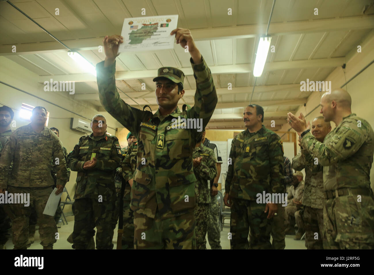An Afghan National Army soldier holds his certificate of completion ...