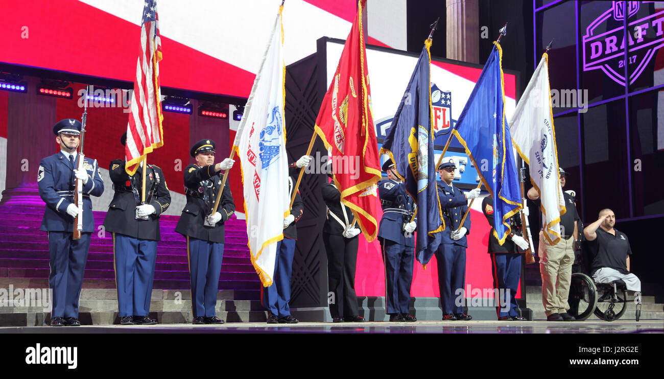 A Joint Service Color Guard displays the American flag and rifles ...