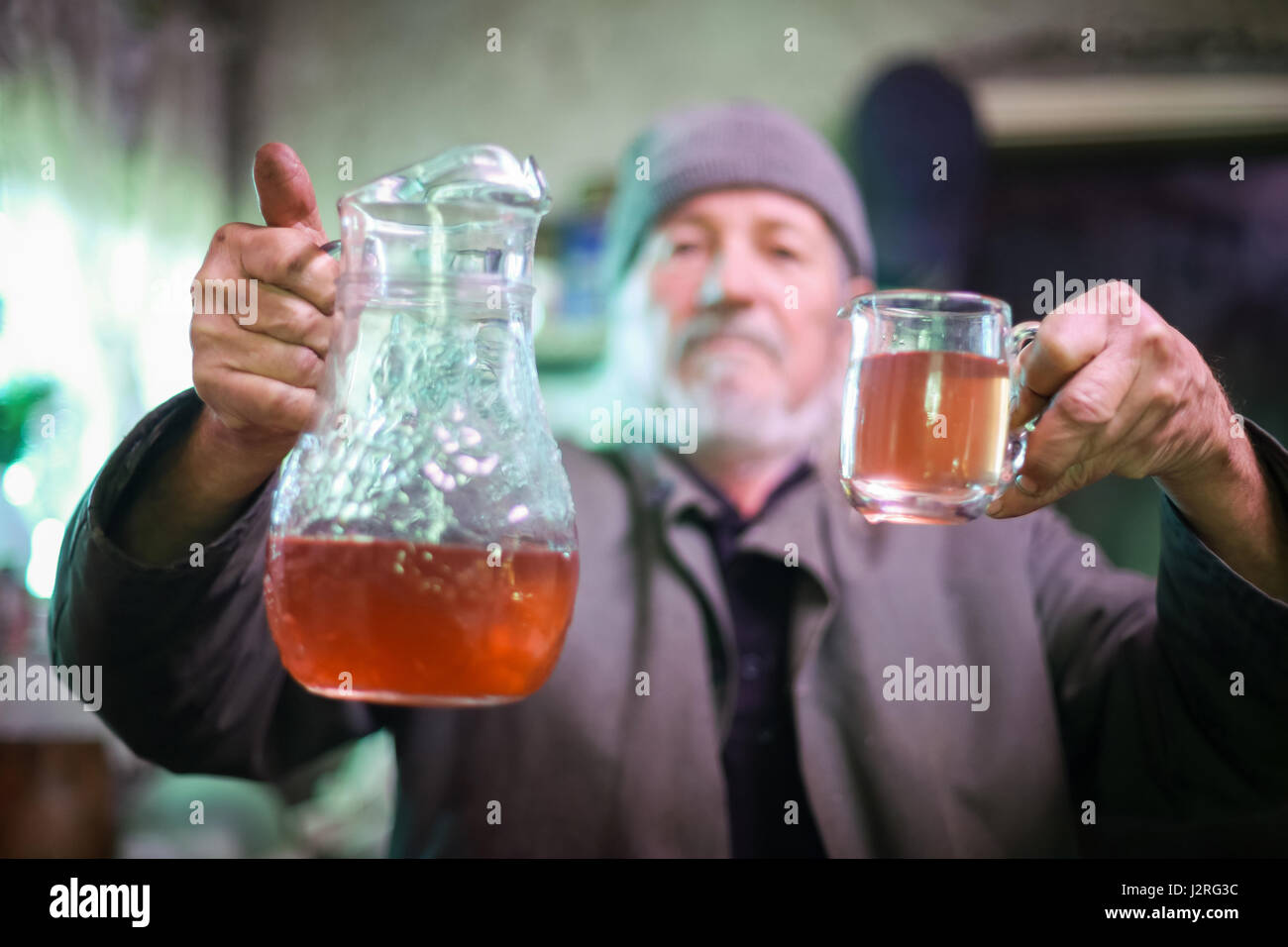 A front view of an old man with a pitcher of wine and a glass Stock ...
