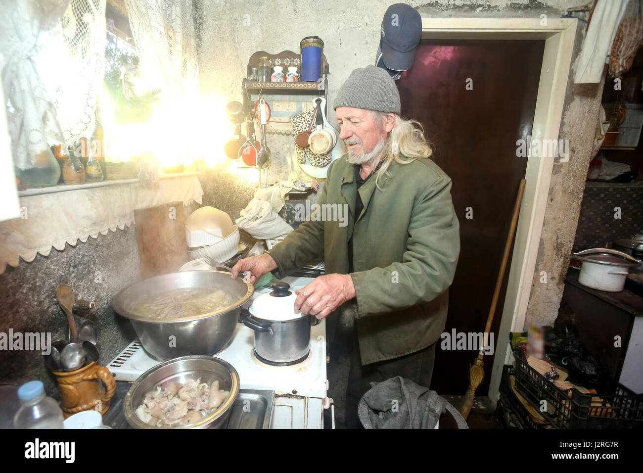 An old man boiling pork meat on the stove Stock Photo - Alamy
