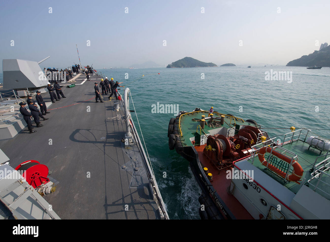 Sailors aboard Arleigh Burke-class destroyer USS Sterett secure a line ...