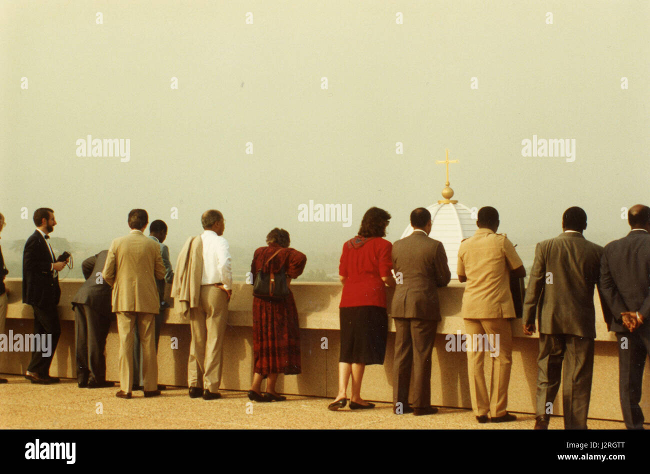 A GROUP OF MEN AND WOMEN LOOKING OVER THE ROOF OF THE CHURCH Stock ...