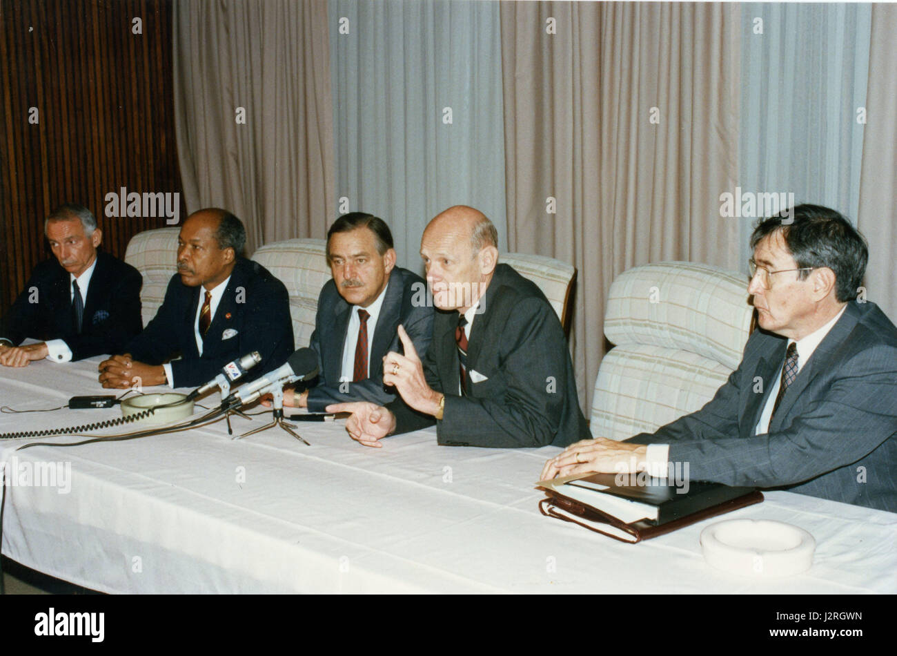 FIVE MEN SITTING AT THE TABLE HAVING A CONVERSATION WITH SOME OTHER ...