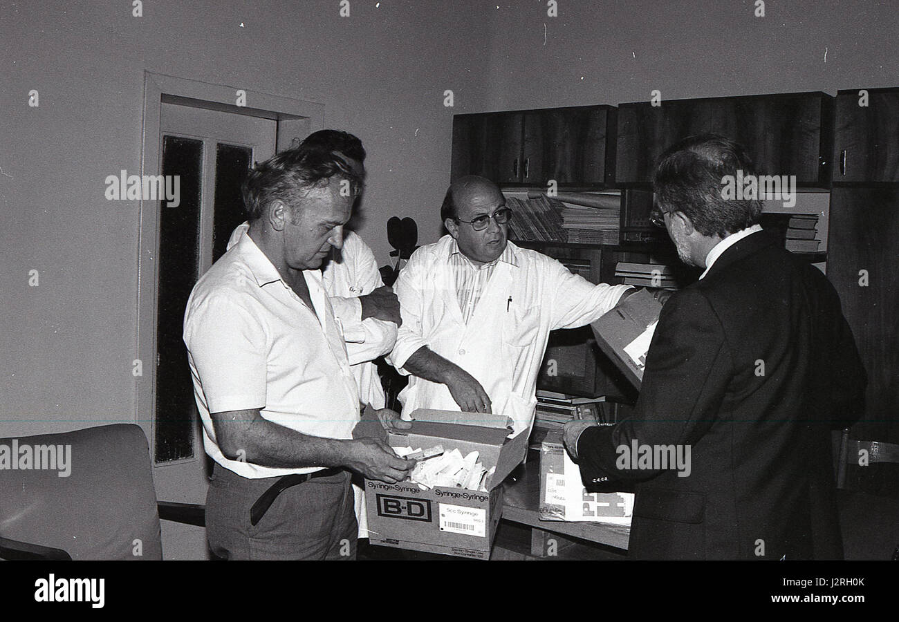 MEN OBSERVING OBJECTS IN A BOX Stock Photo - Alamy