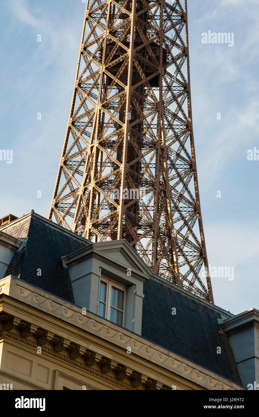 Eiffel Tower rising above the dormer window and roof in Paris, France ...