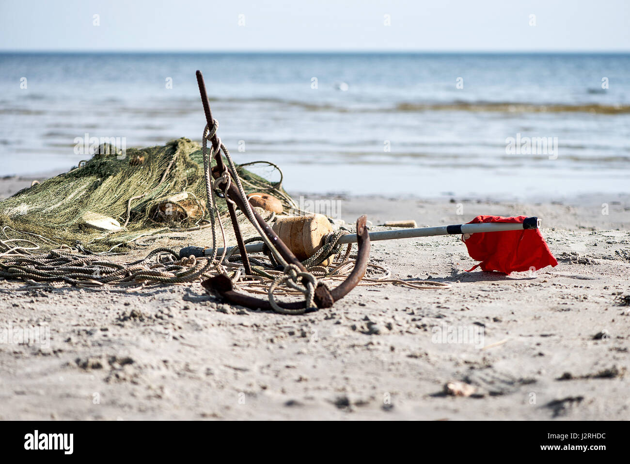 Boats anchor and fishing nets in the beach sand Stock Photo - Alamy