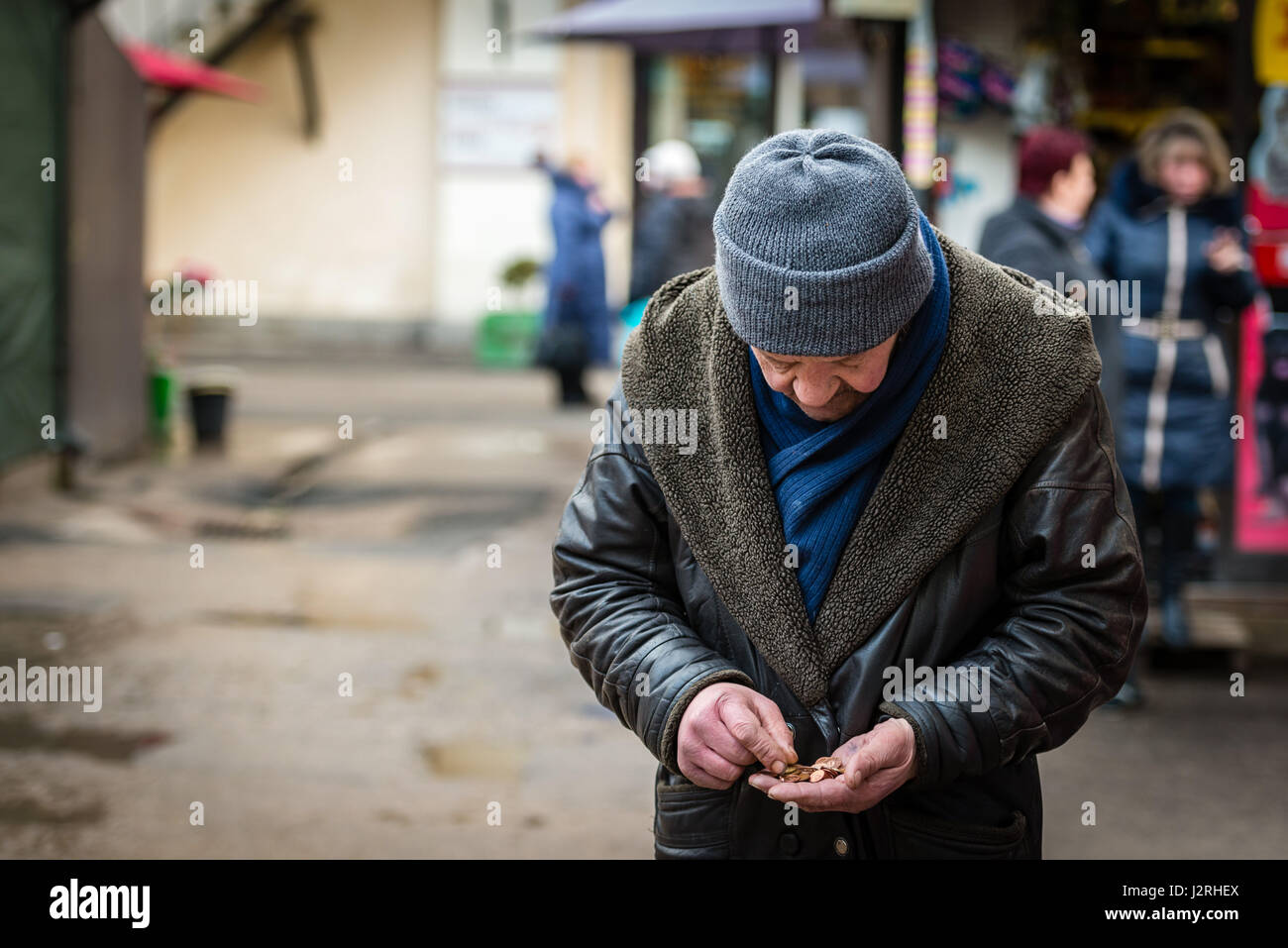 RIGA, LATVIA - FEBRUARY 24, 2016: Unknown man in the street count the ...