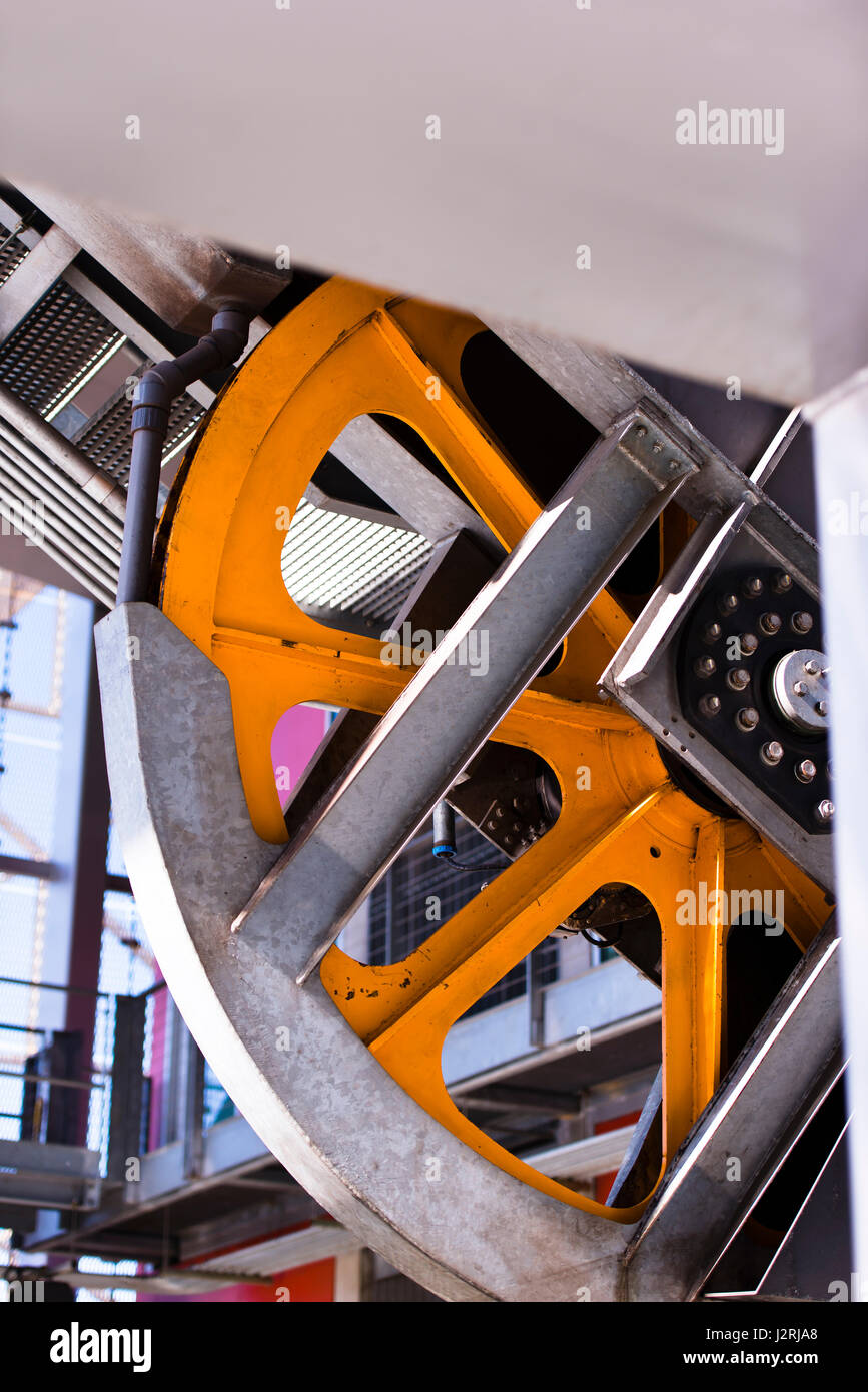 Large Industrial metallic orange flywheel Linkage and connections to ...