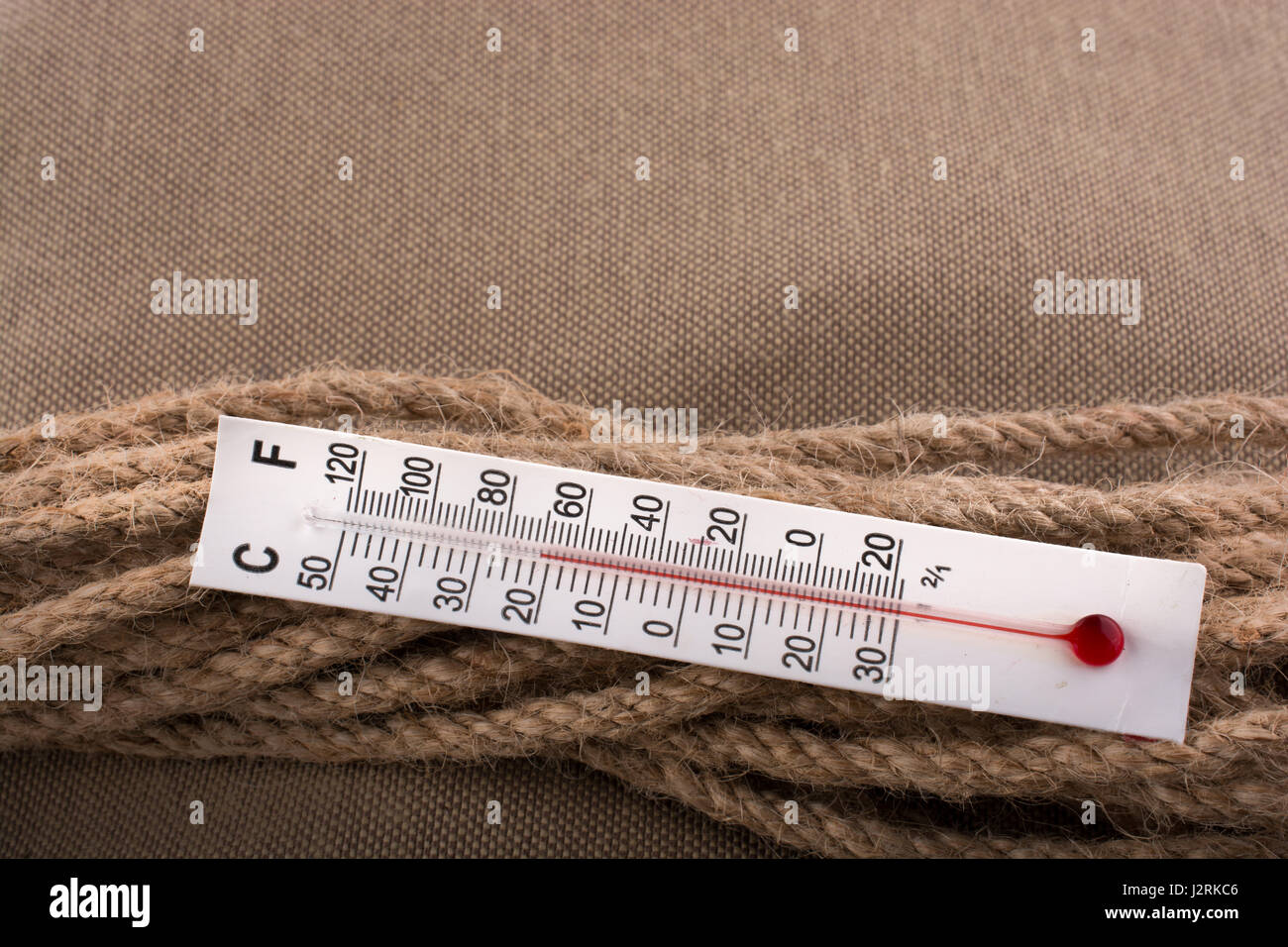 Thermometer placed on a brown rope on a fabric background Stock Photo ...