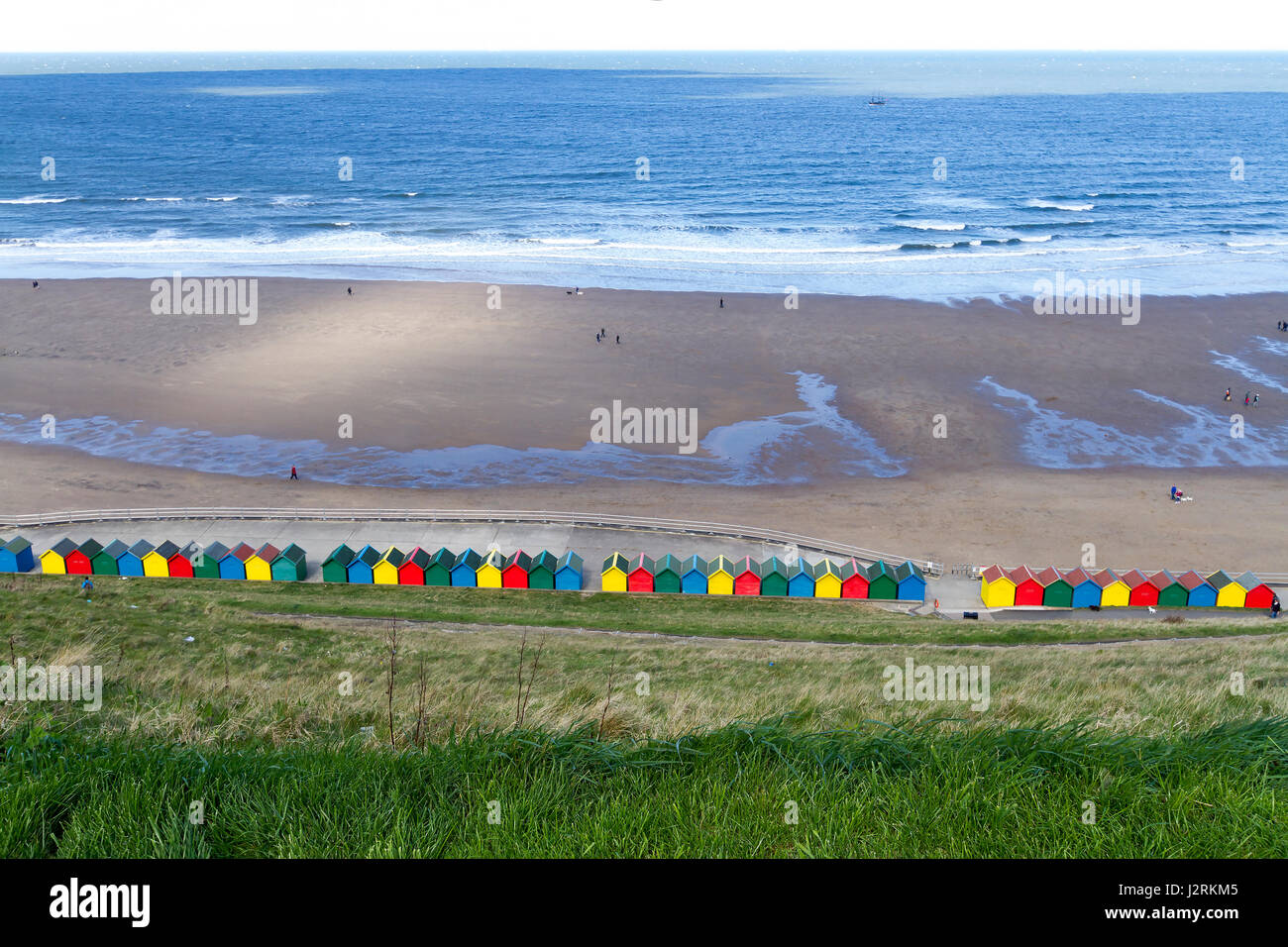 Row of brightly coloured wooden beach huts along the West Cliff ...