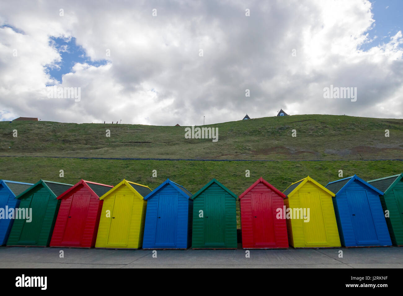 Row of brightly coloured wooden beach huts along the West Cliff ...