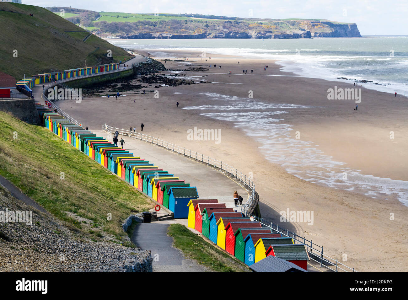Row of brightly coloured wooden beach huts along the West Cliff ...