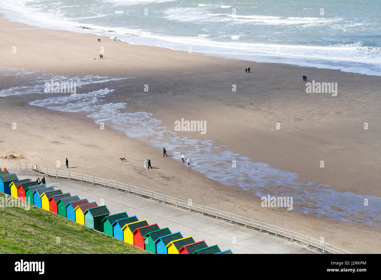 Row of brightly coloured wooden beach huts along the West Cliff ...