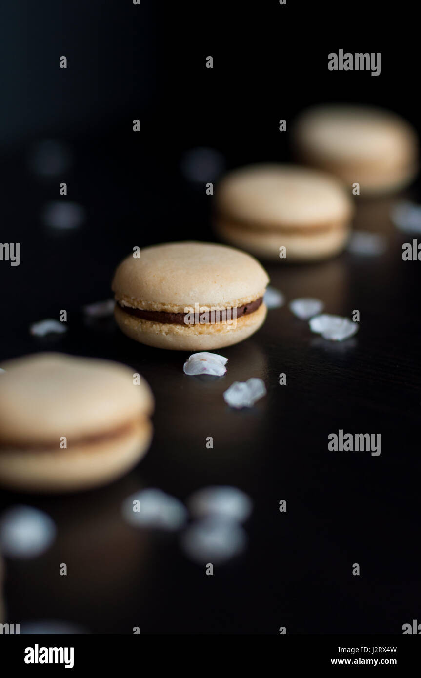 Macaroons with chocolate cream ordered in line decorated with pebbles ...