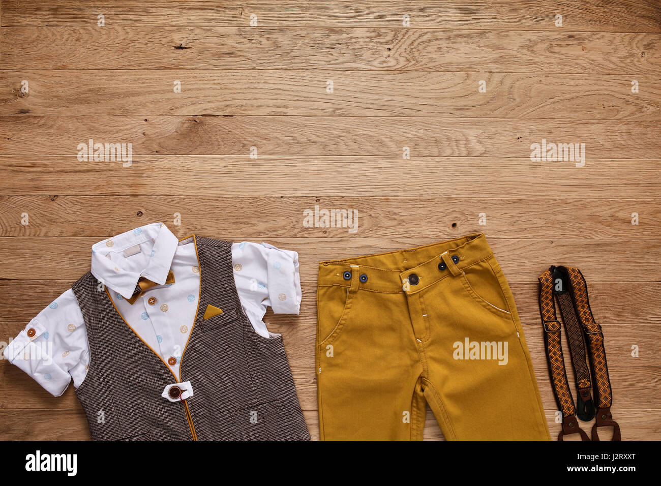 Top view photo of the boy's clothes with accessories on the wooden ...