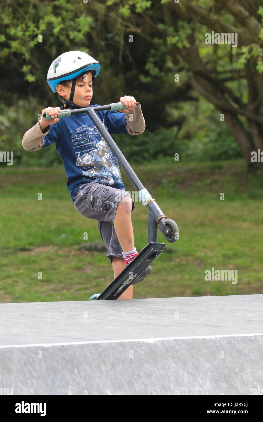 Young boy on his stunt scooter at skate park, Bracknell, Berkshire UK ...