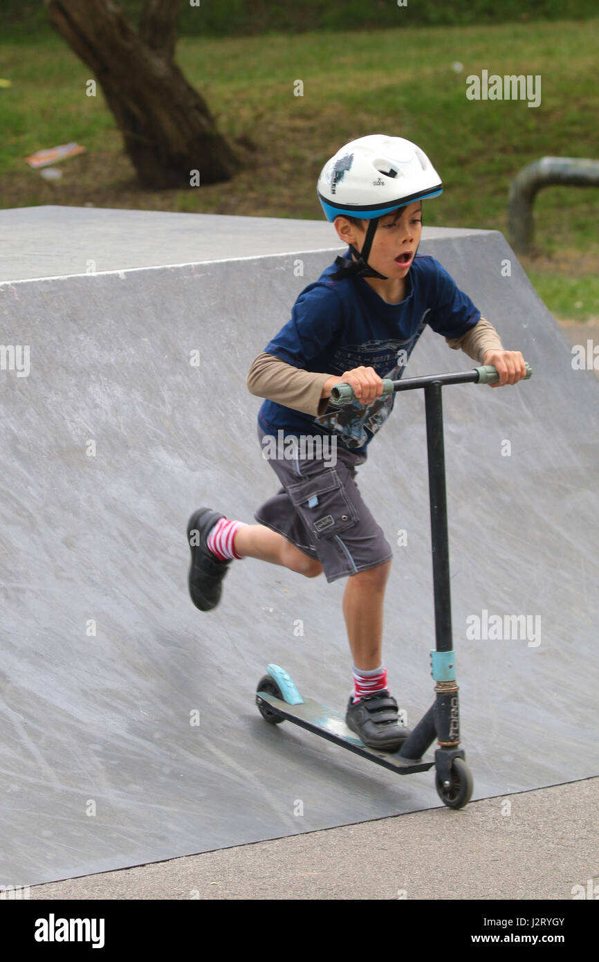 Young boy on his stunt scooter at skate park, Bracknell, Berkshire UK ...