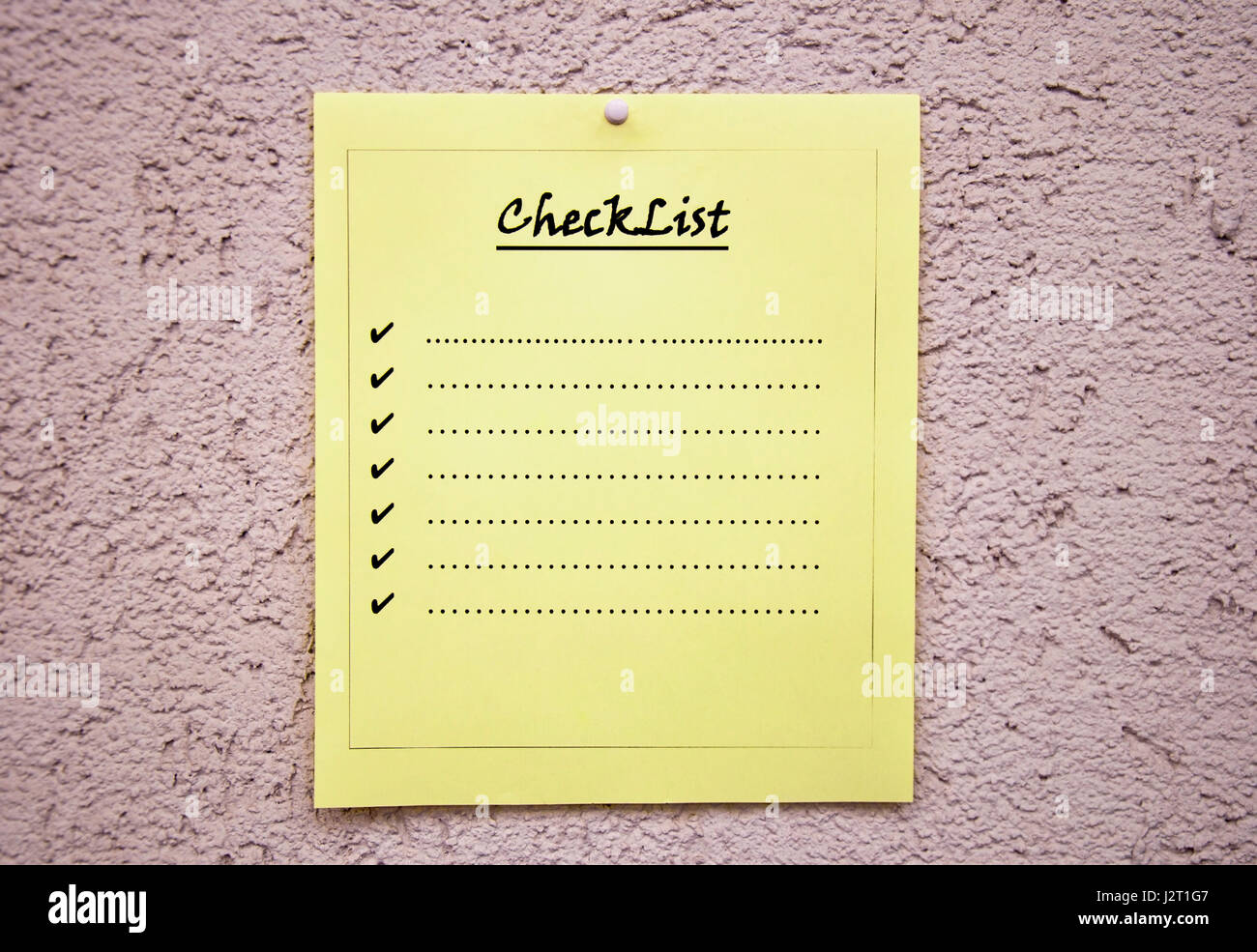 Yellow checklist on the wall Stock Photo - Alamy